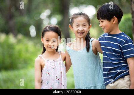Three Chinese children playing on grass Stock Photo - Alamy