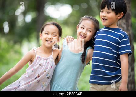 Three Chinese children playing on grass Stock Photo - Alamy