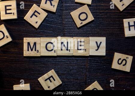 Money word made with scrabble letters on a black wooden table Stock ...