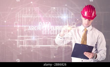Handsome architect with helmet drawing DATA ARCHITECTURE inscription ...