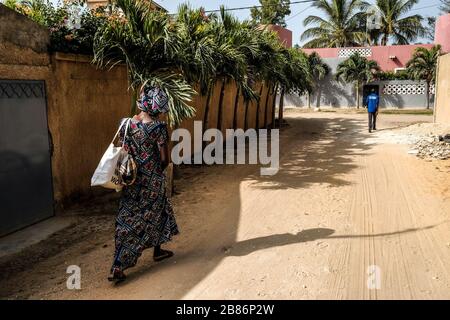 A woman walks along an almost empty Tidal Basin lined with cherry ...