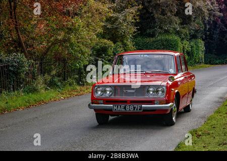 Detail of a small red vintage car with headlight and sideview mirror ...
