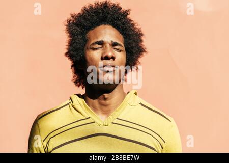 Cuban black man enjoying the andalusian sun with his eyes closed on his ...