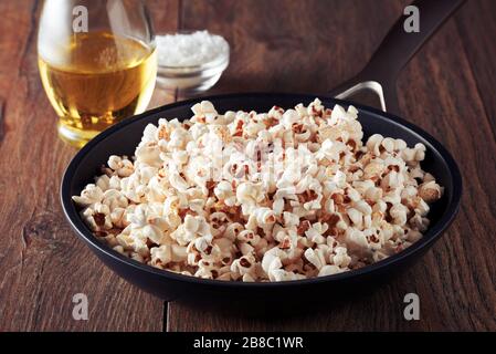 delicious popcorn in frying pan and on wooden table Stock Photo - Alamy