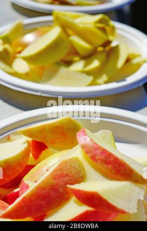 Slices of fresh apples for tasting on paper plates at an outdoor ...