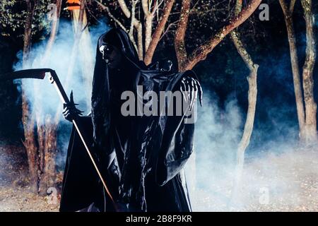 Grim Reaper standing in the fog at night with his scythe Stock Photo ...