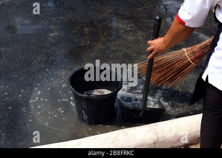 people are sweeping dirty water at ground streets, cleaner floor ...