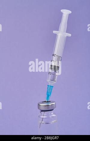 Syringe, needle and medicine vial. The needle sticks through the ...