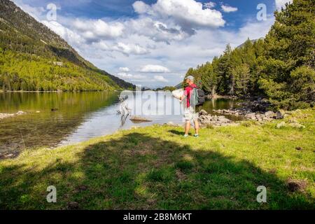 Beautiful Pyrenees mountain landscape, nice lake with tourist couple ...