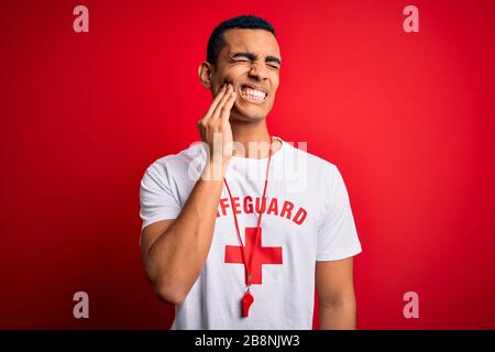 Young handsome african american lifeguard man wearing whistle holding ...