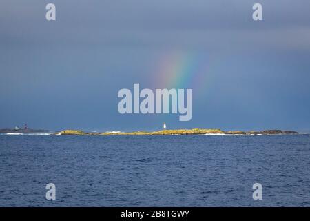 Sunbeam and rainbow over the lighthouse between Torvik and Ålesund on ...
