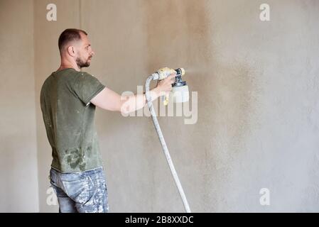 Man holding spray paint against white background, back view Stock Photo ...