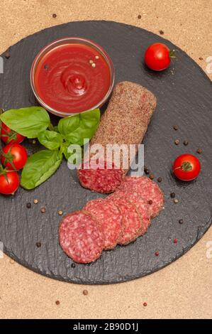 Plate with slices of delicious jamon and tomatoes on color background ...