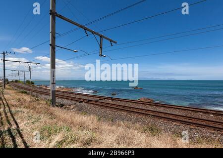 Road and railway track along coast at sunset over Indian ocean. Train ...
