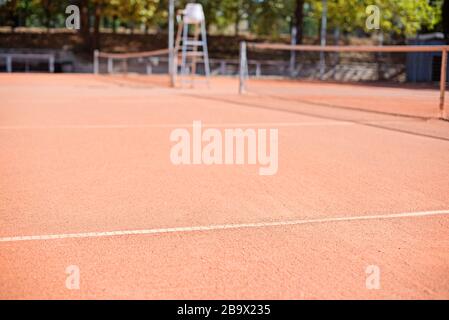 Sand and gravel tennis court sub-base. Blurred background. Coral tones ...