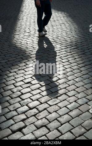 Silhouette of a person walking in a dark pedestrian underpass towards ...