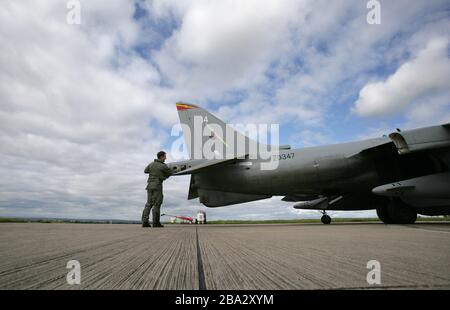 Flight Lieutenant Andy Chisholm, checks over his Harrier before the ...
