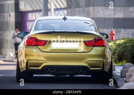Golden sport sedan car back view with red xenon lights parked in the ...