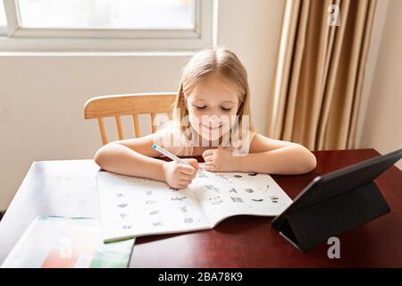 Child girl studying homework during online lessons at home. Kid ...