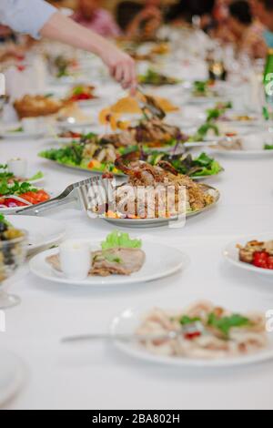 Catering table - hand with tongs taking a food Stock Photo - Alamy