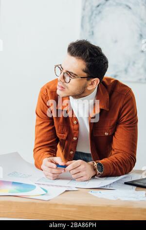 Selective focus of ux developer looking at wireframe sketches of ux ...