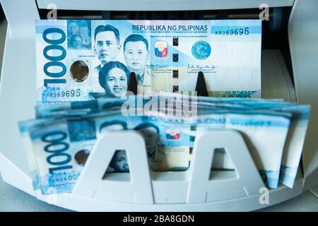 Close up view of a 1000 Philippine peso cash exiting the money counter ...