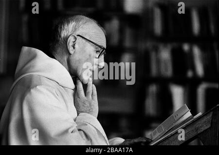 A monk with a bible in the library at Sancta Maria Abbey at Nunraw ...