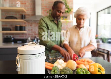 Senior african american couple cooking together in kitchen smiling ...
