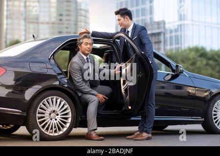 Confident Chinese businessman getting out of car Stock Photo - Alamy
