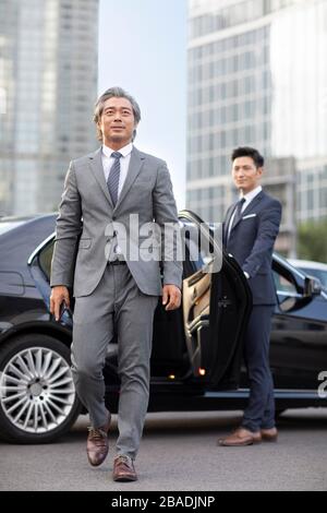 Confident Chinese businessman getting out of car Stock Photo - Alamy
