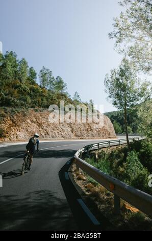 Cyclist speeding through a corner into sunlight Stock Photo - Alamy