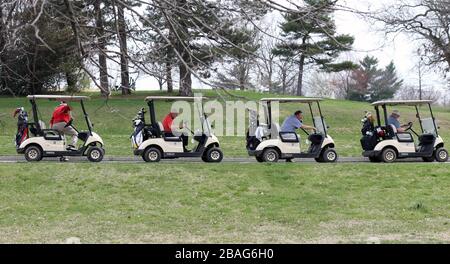 Golfers wait in the carts during the Bay Breeze Golf Course reopening ...