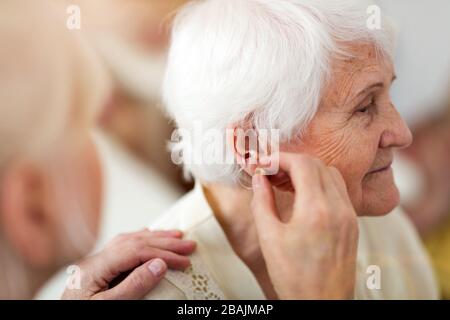 Aging hearing loss with an elderly ear close up of an old man with grey ...