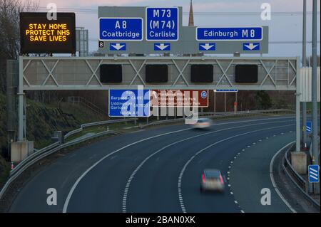 Overhead gantry sign on M8 motorway showing message 'caution debris ...