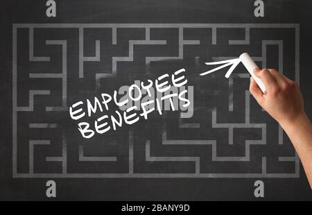 Hand drawing EMPLOYEE BENEFITS inscription with white chalk on ...