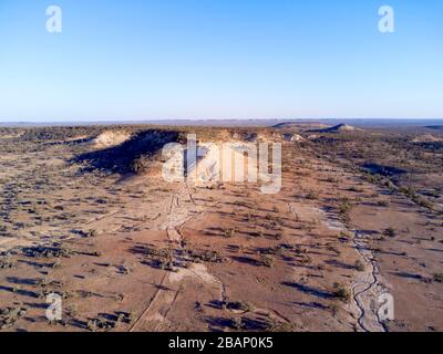 Aerial of dry creek as it passes through arid landscape near ...
