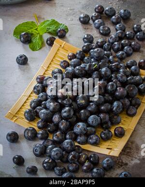 Juicy and fresh blueberries with green mint leaves on wooden table ...