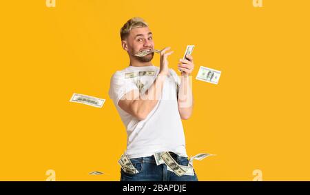 Guy holds banknote in his teeth and scatter money Stock Photo - Alamy