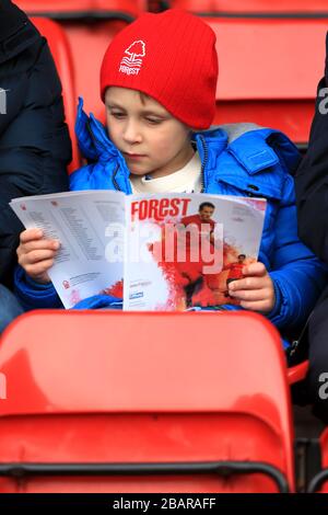 A Nottingham Forest fan reads the matchday programme ahead of the ...
