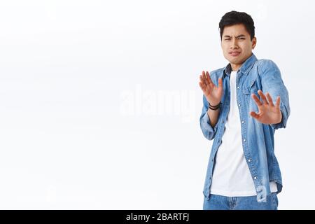 Stay away from me. Reluctant young man step back with hands stretch out ...
