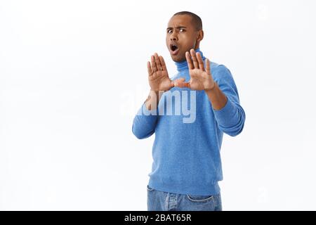 Stay away from me. Reluctant young man step back with hands stretch out ...