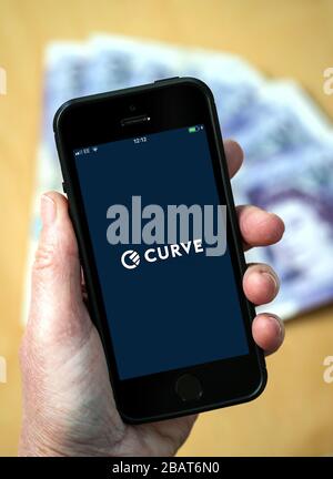 A woman using the Curve banking app on a mobile phone. (Editorial Use ...