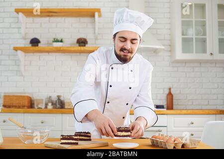 A male pastry chef works decorating a cake on a kitchen bakery Stock ...