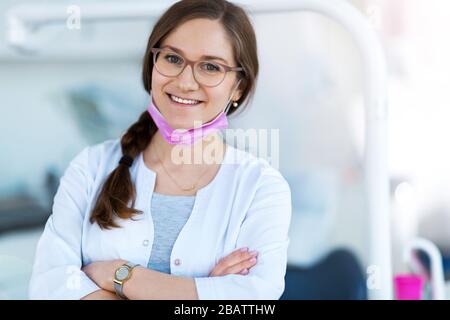 Confident female dentist in dental office with male patient in chair ...