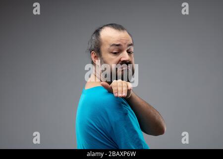 Man with grimace of disgust brushing shoulder Stock Photo - Alamy