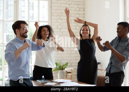 happy multiethnic business team dancing during moving in at new ...