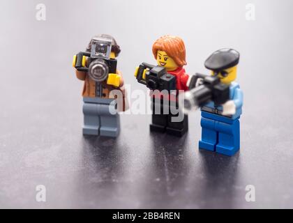 2 girl mini-figure lego people sitting on a giant yellow lego block ...