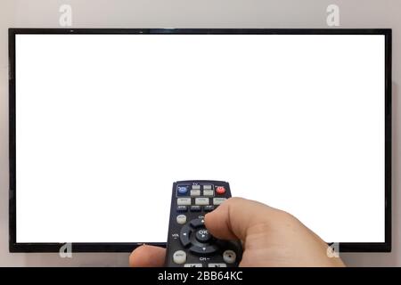 Person pointing a TV remote and pressing buttons in front of a TV with ...