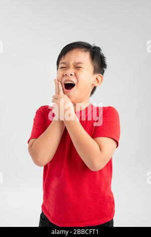 Child toothache. holding his cheek, dental pain. Closeup portrait boy ...