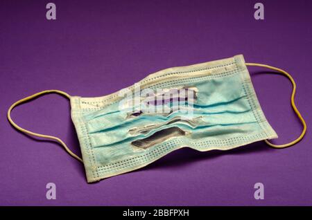 Used, broken, and torn medical face mask. Showing dangerous lack of ppe ...